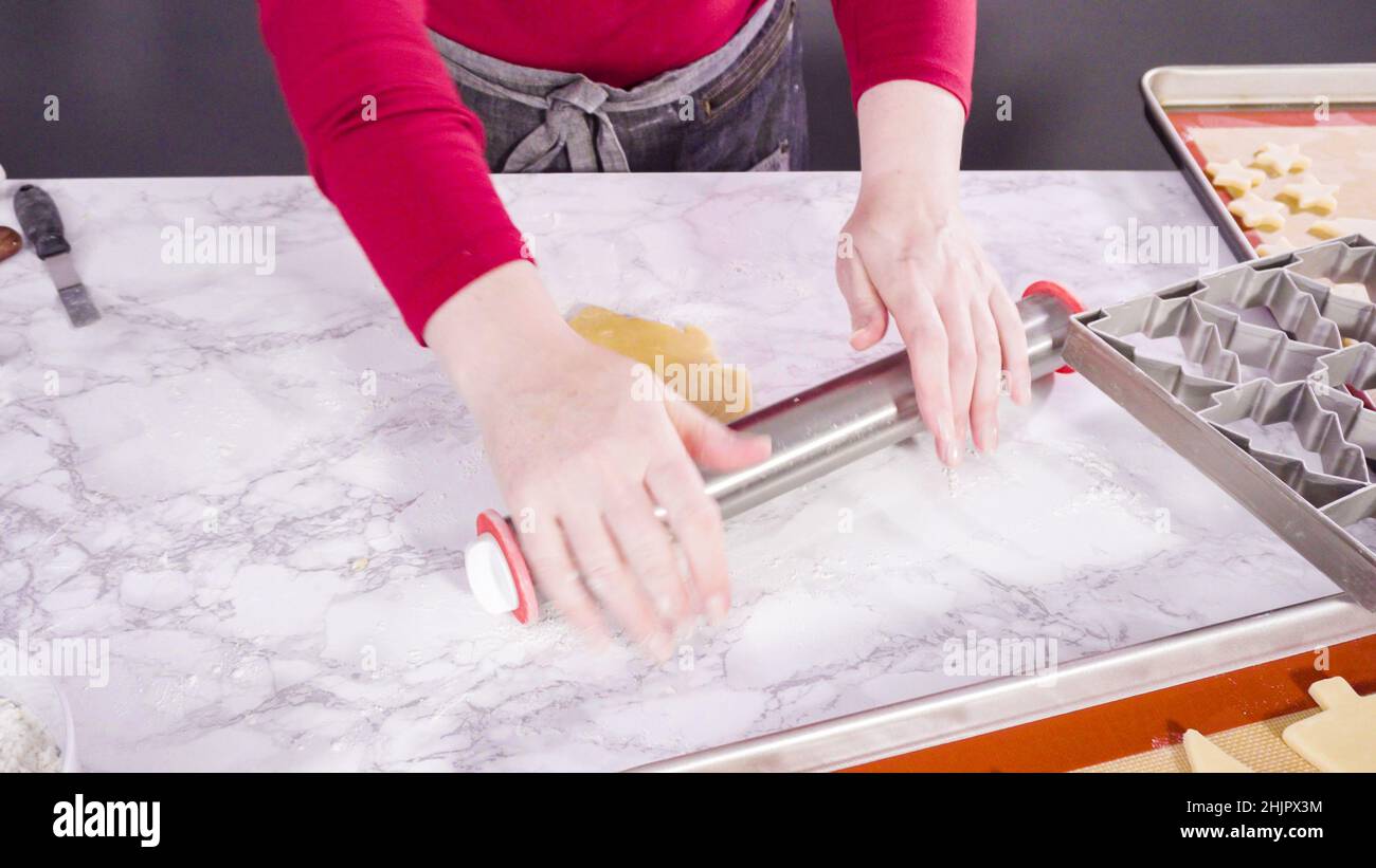 Rolling out sugar cookie dough to bake Christmas cookies Stock Photo ...