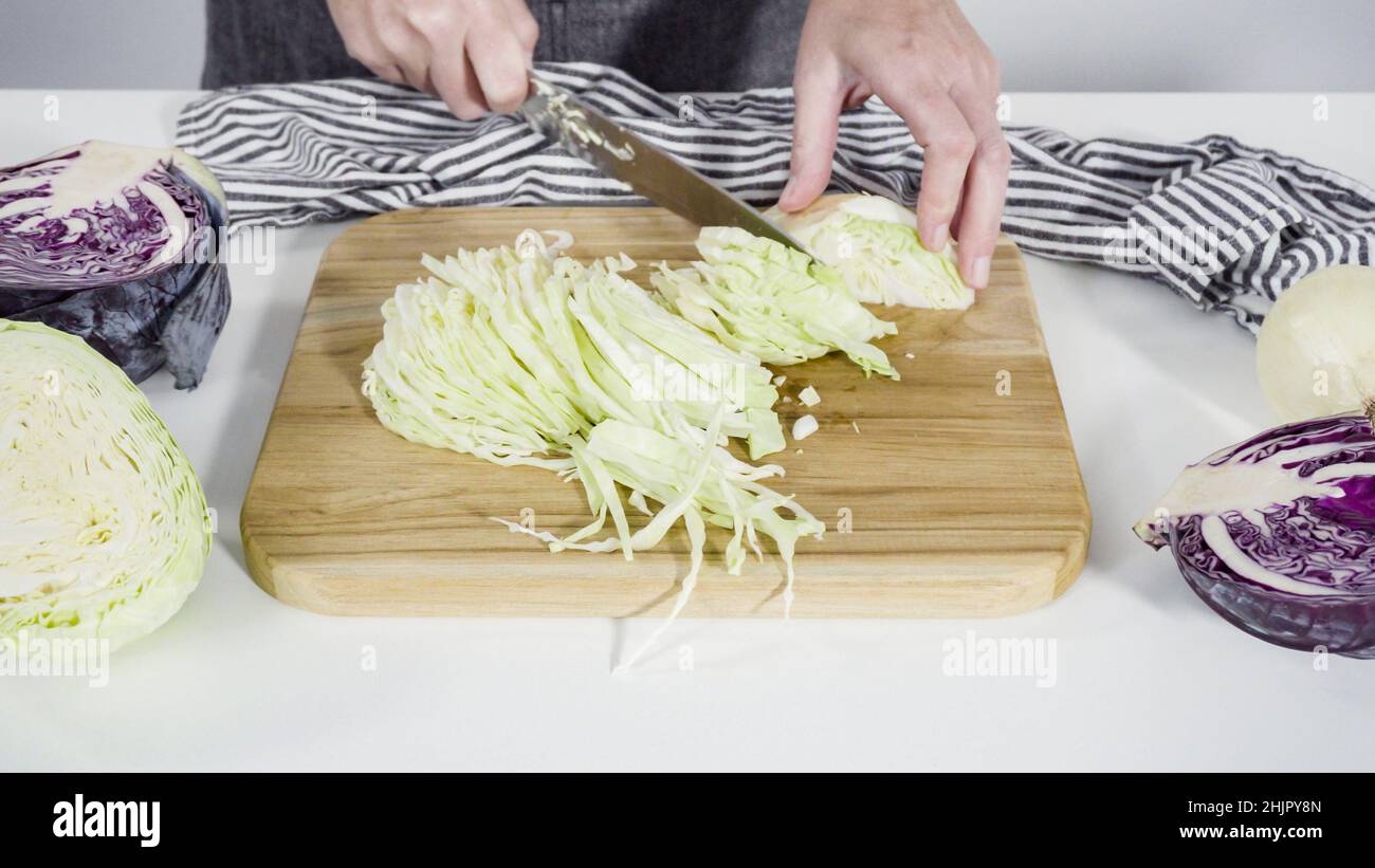 Step by step. Shredding organic cabbage on a wood cutting board Stock ...