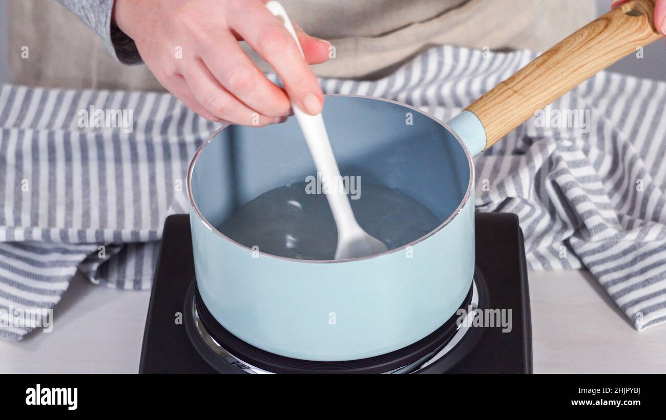 Step by step. Preparing sugar syrup in a small saucepan over an ...