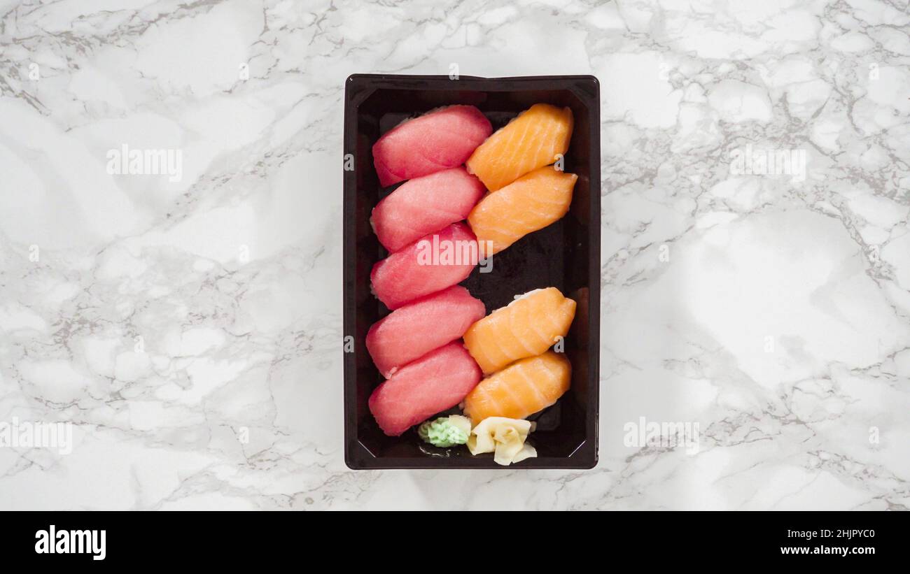 Flat lay. Pre-packaged variety of sushi and sushi rolls in a plastic ...
