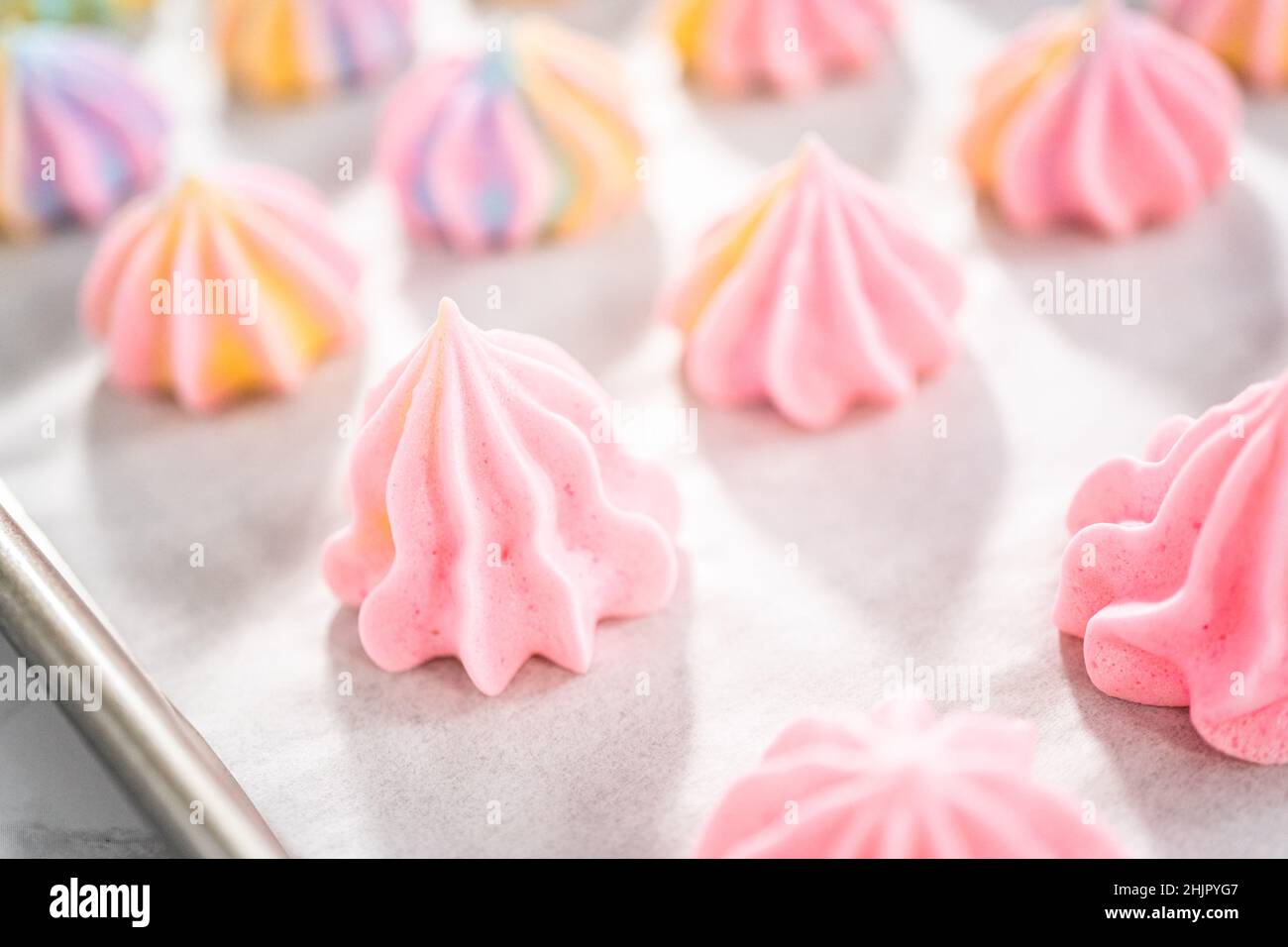 Freshly baked unicorn meringue cookies on a baking sheet with a ...