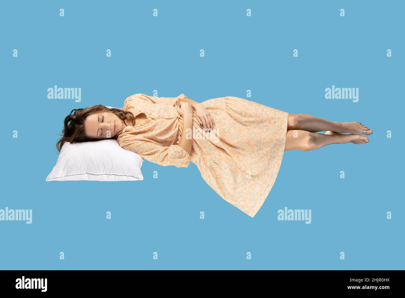 Sleeping beauty hovering in air. Relaxed girl in yellow dress lying ...