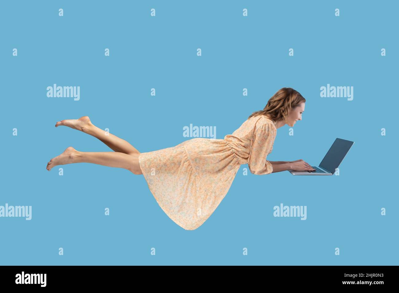 Hovering in air. Happy cheerful girl in yellow dress levitating with ...