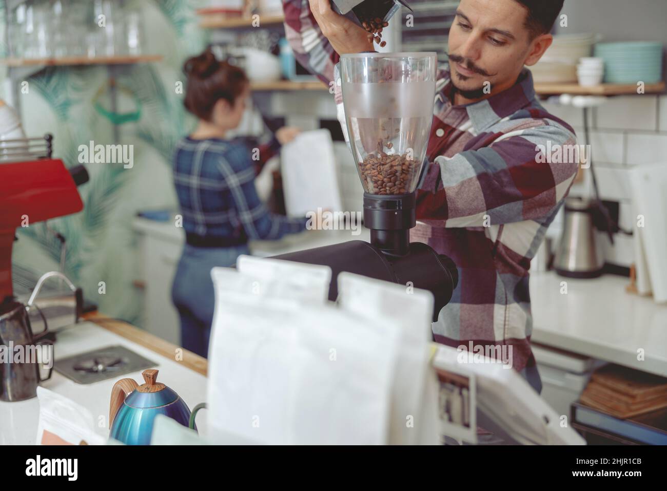 Man grinding coffee beans in electric grinder Stock Photo - Alamy