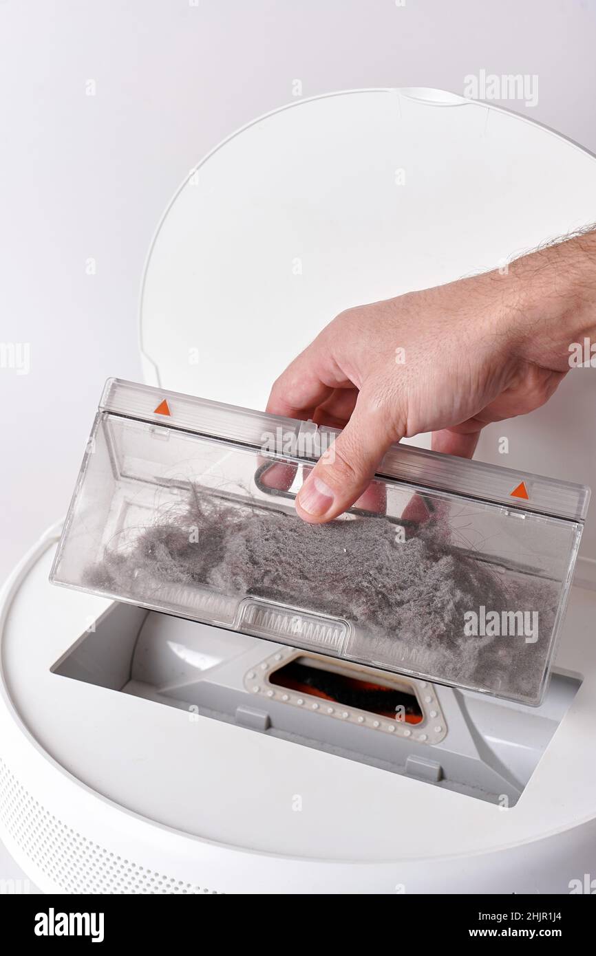 Take out the transparent dust container from the robot vacuum cleaner ...