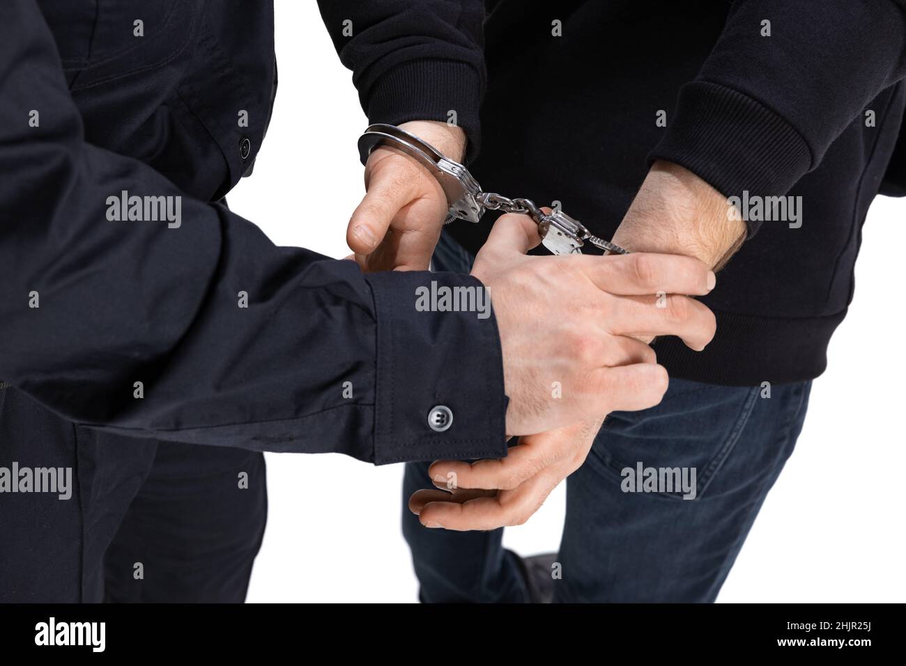Close-up male hands in handcuffs. Policeman officer arrests a criminal ...