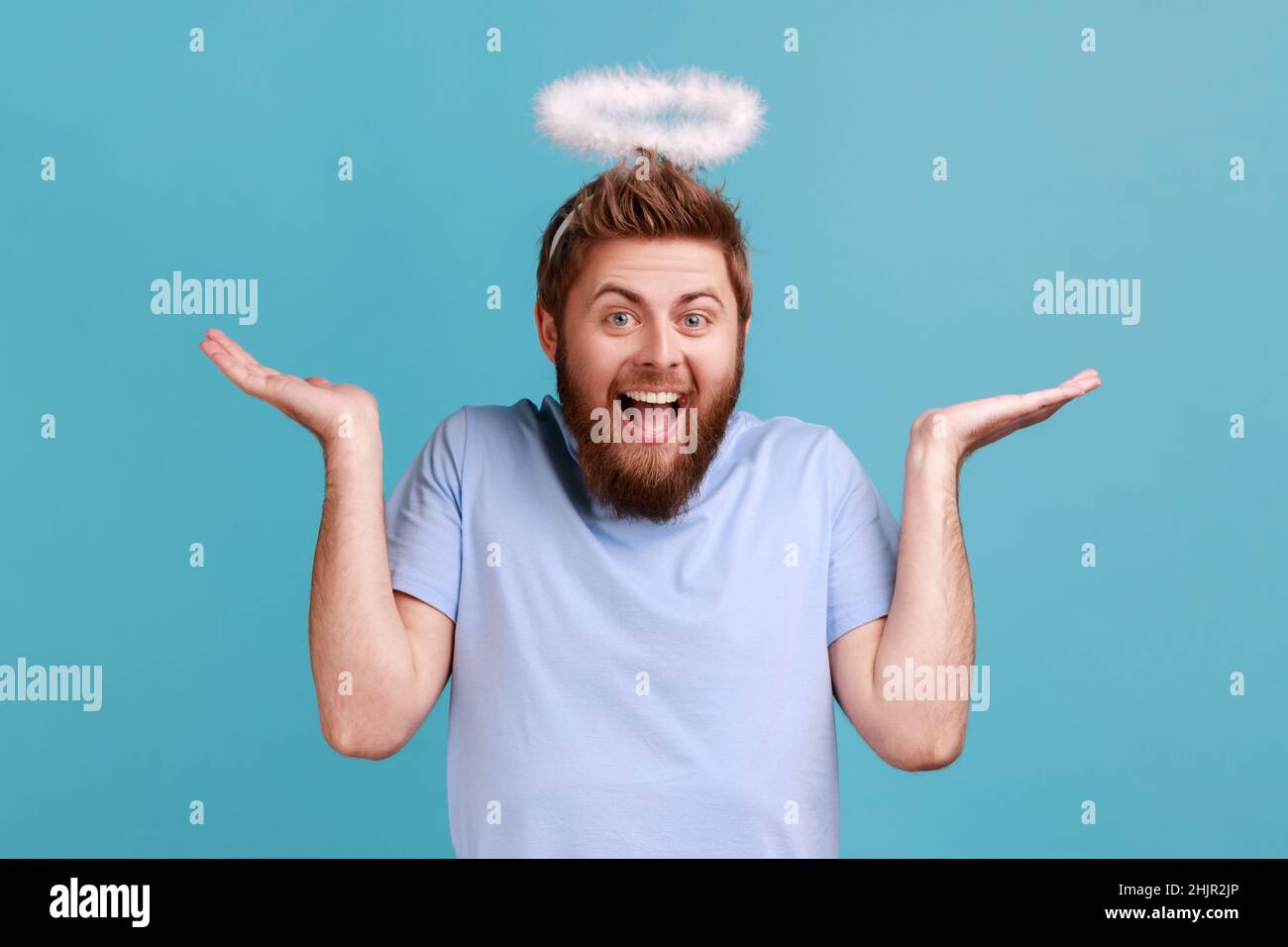 Portrait of bearded angelic man with holy nimbus looking at camera with ...