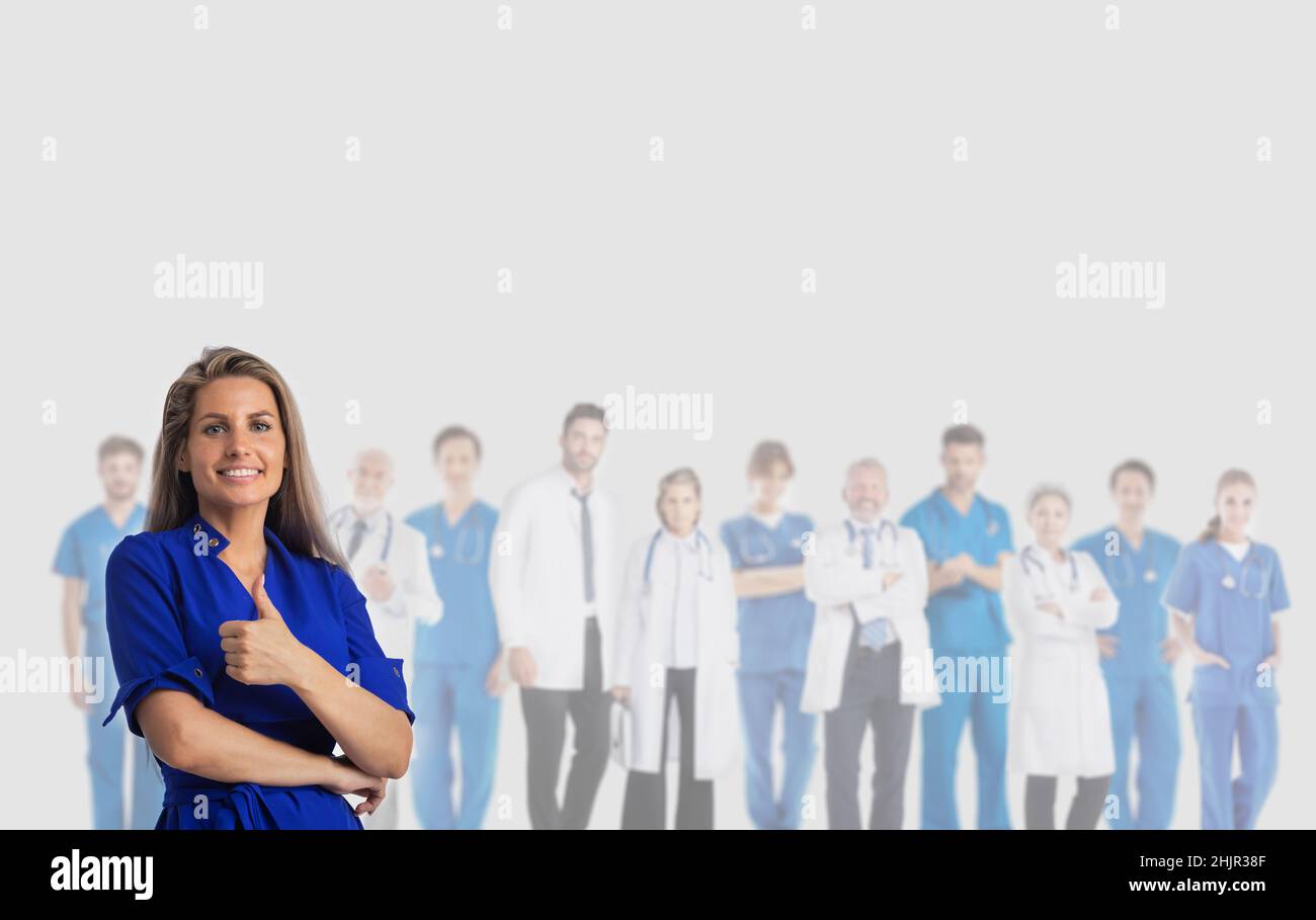 Happy female patient with thumb up and team of doctors isolated on gray ...