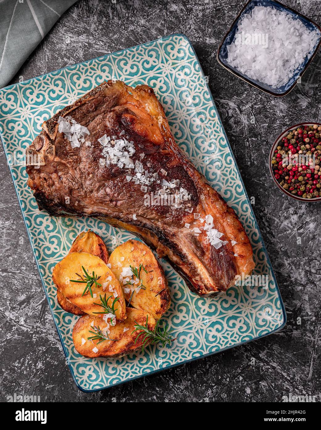 GRILL BEEF CHOP WITH BAKED POTATOES, SALT AND PEPPER Stock Photo - Alamy