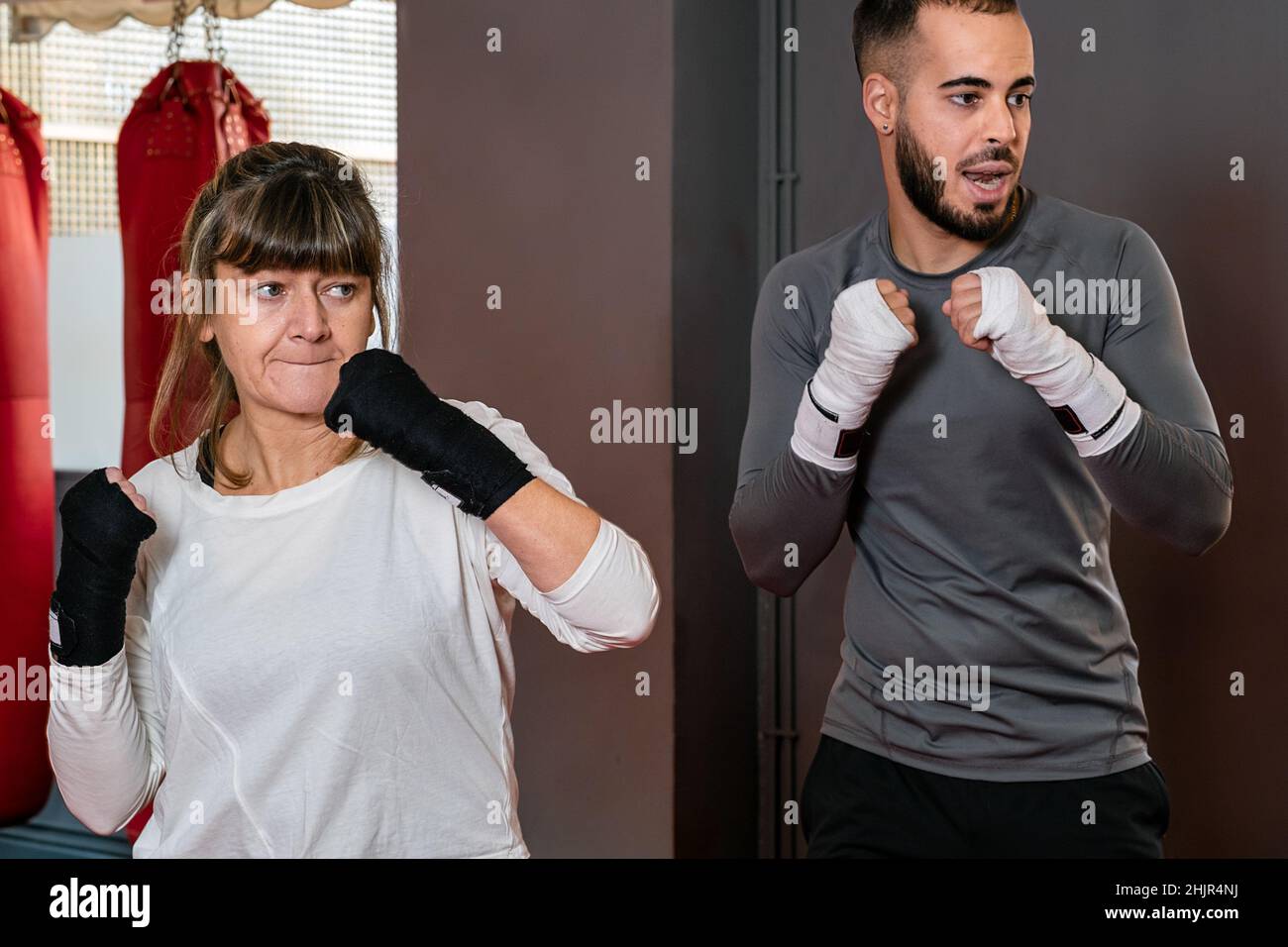 Boxing teacher teaching mature woman how to box Stock Photo - Alamy