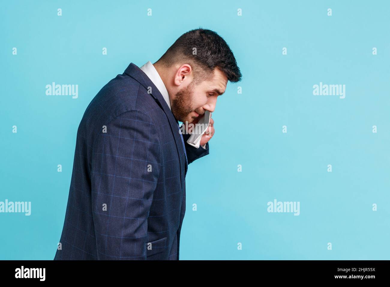 Side view of depressed brunette man with beard wearing official style ...