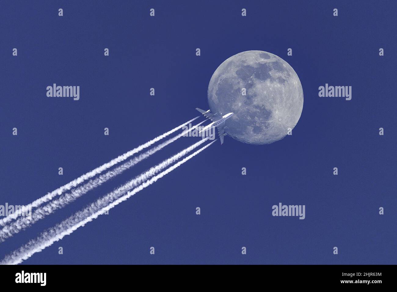 Low angle of an airplane flying under the moon at daytime Stock Photo ...
