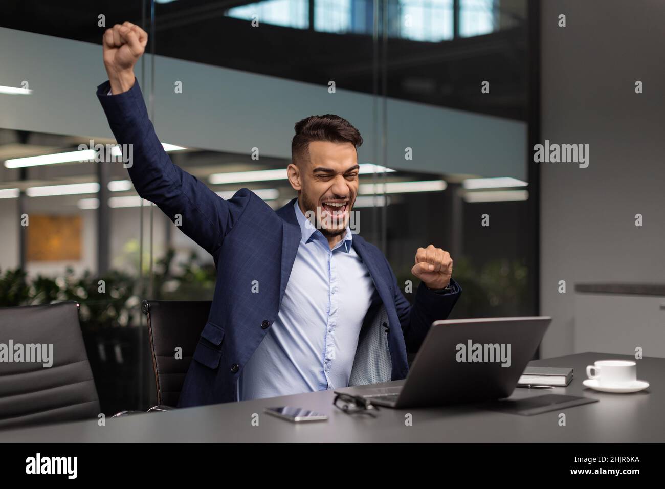 Emotional arab manager celebrating success at office Stock Photo - Alamy