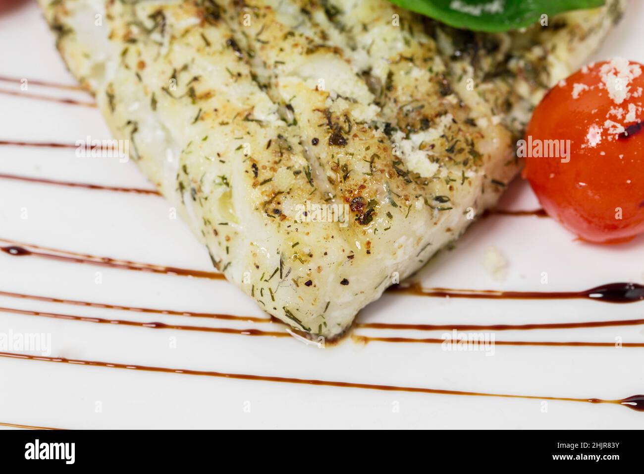 Baked fish fillet with tomatoes and basil. Macro. Can be used as a ...