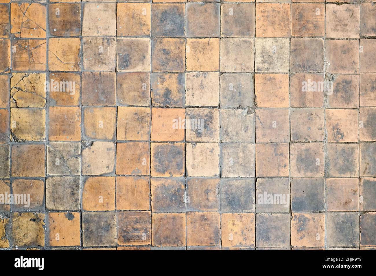 Orange brown white beige old shabby worn out floor tiles with damages ...
