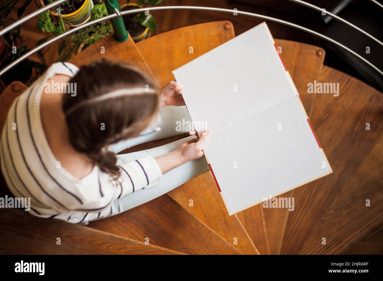 The girl on the stairs reading a book Stock Photo - Alamy