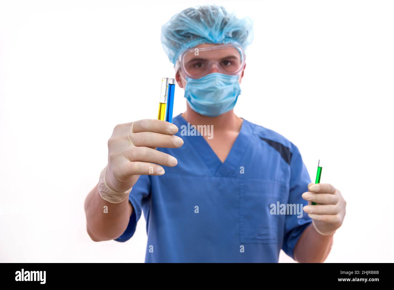 Chemist in protective uniform holding flask and test tube with minerals ...