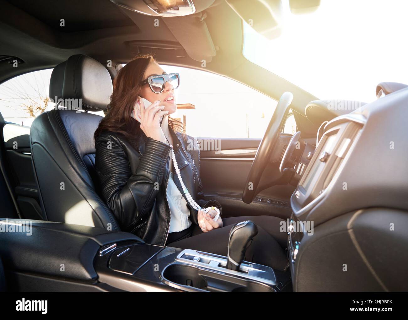 Beautiful woman talking to mobile inside a car Stock Photo - Alamy