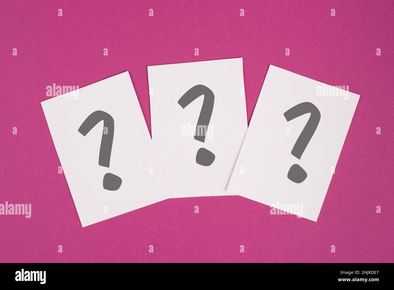 Three colored question marks on paper, vibrant background, looking for ...