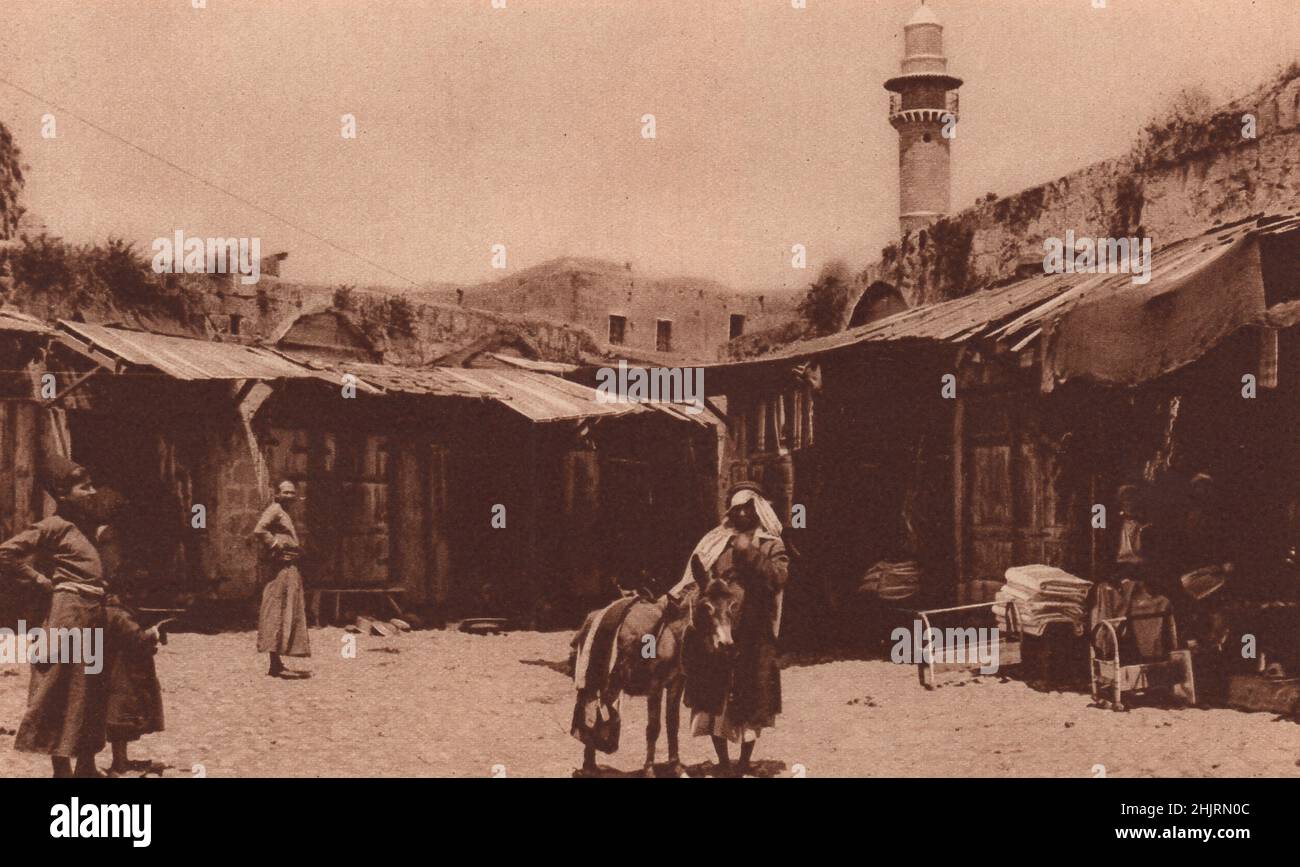 Around the cobbled market-place in Ramleh the merchants sit before the ...