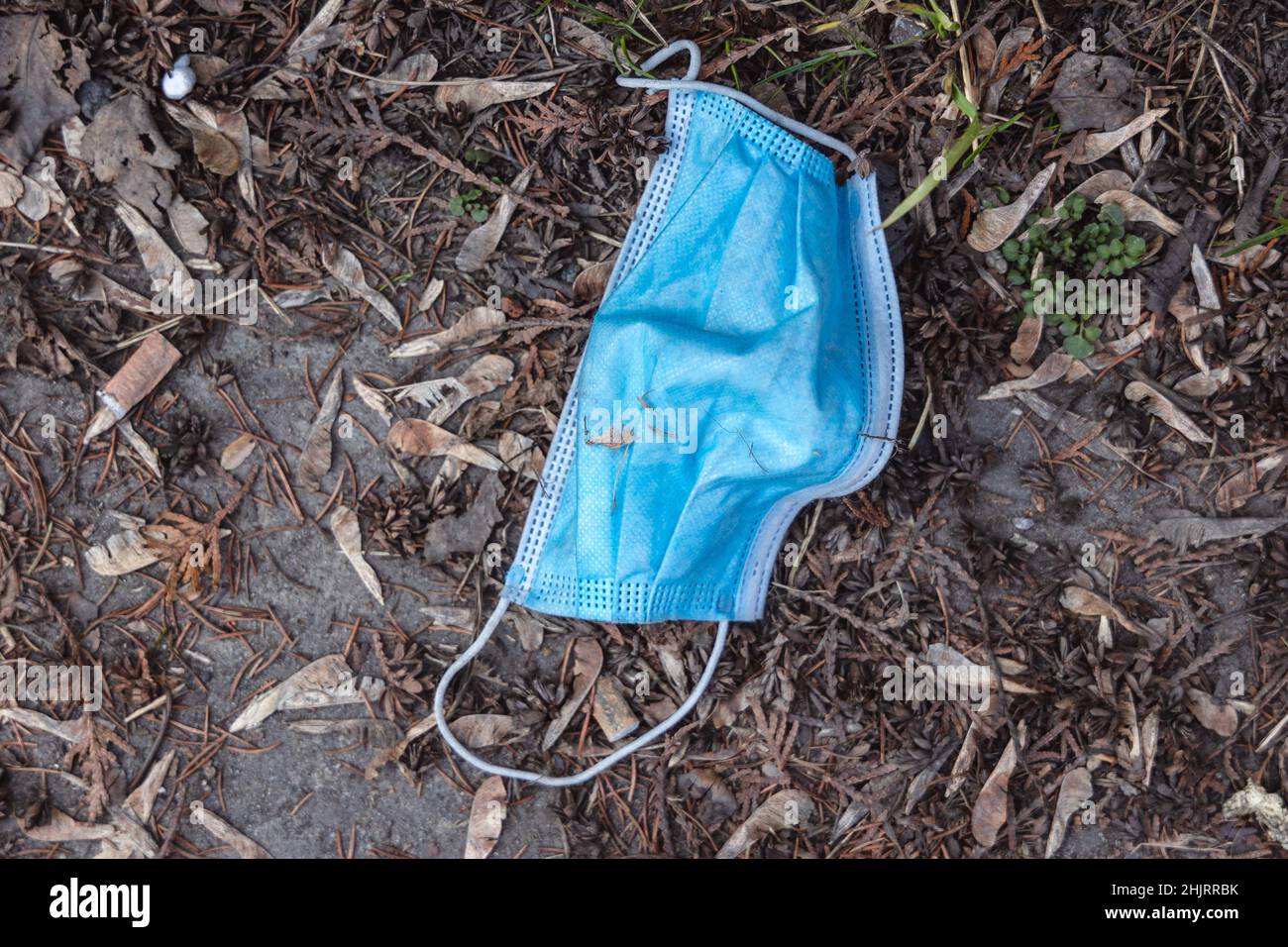 Old face mask thrown on a ground Stock Photo - Alamy