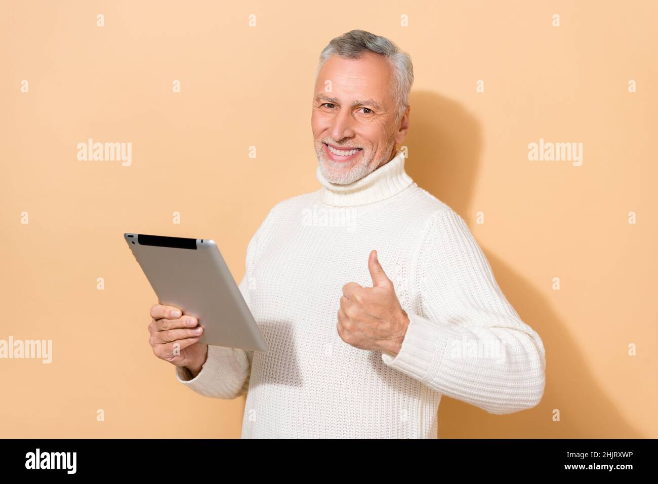 Portrait of attractive cheerful glad grey-haired man using gadget ...