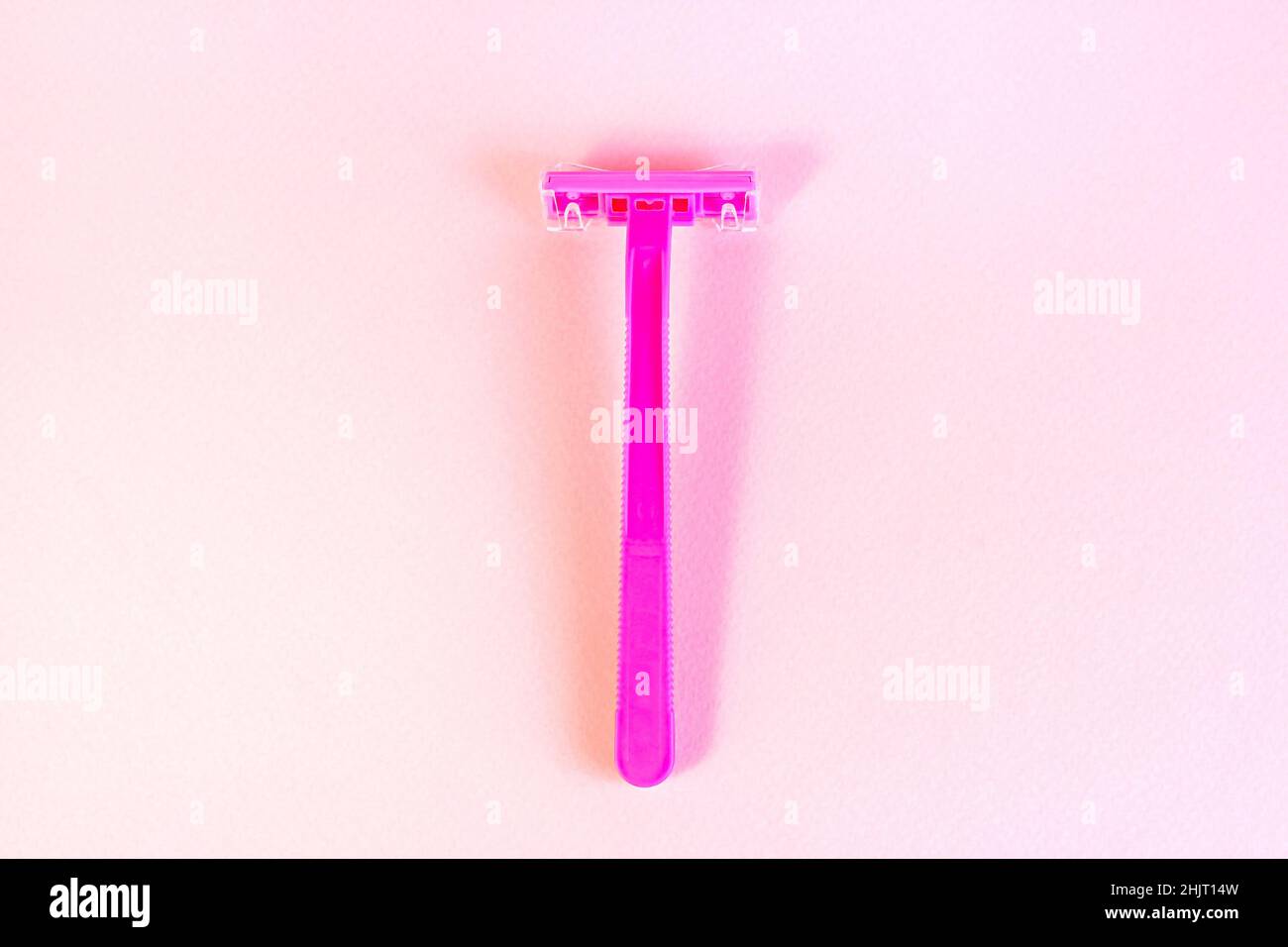 Pink disposable woman razor on light pastel background. Hair removing ...