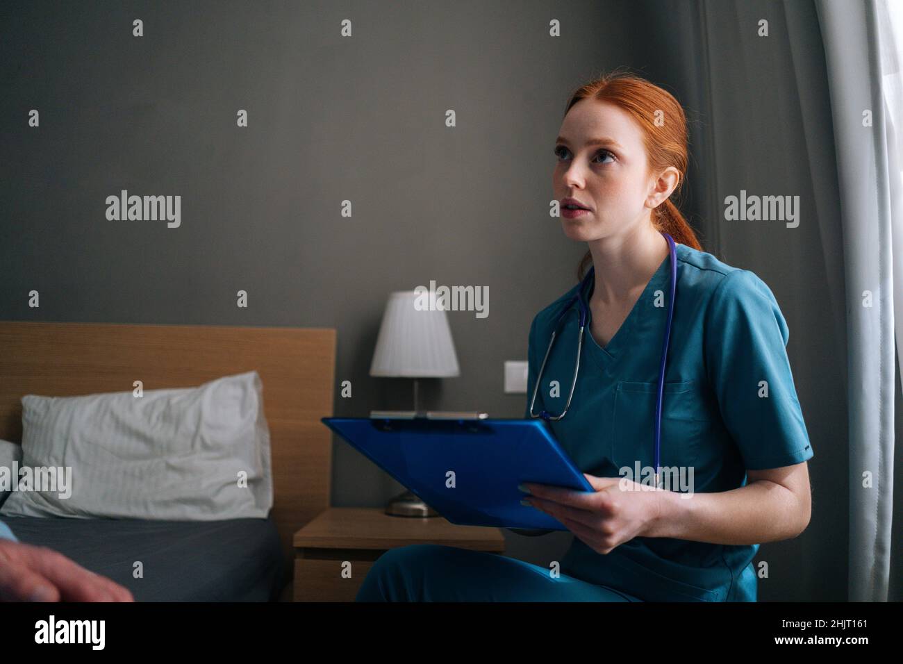 Portrait of focused female doctor talking to unrecognizable patient ...
