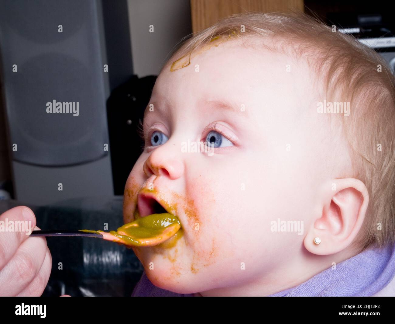 Feeding Baby Face with spoon messy Stock Photo - Alamy