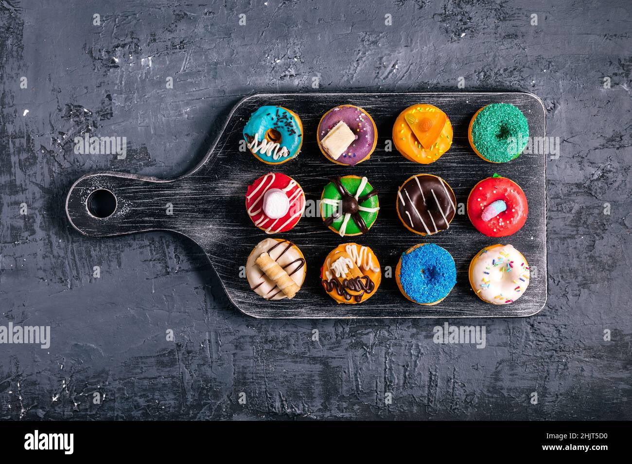Group of colorful mini donuts placed on dark wooden background. Top ...