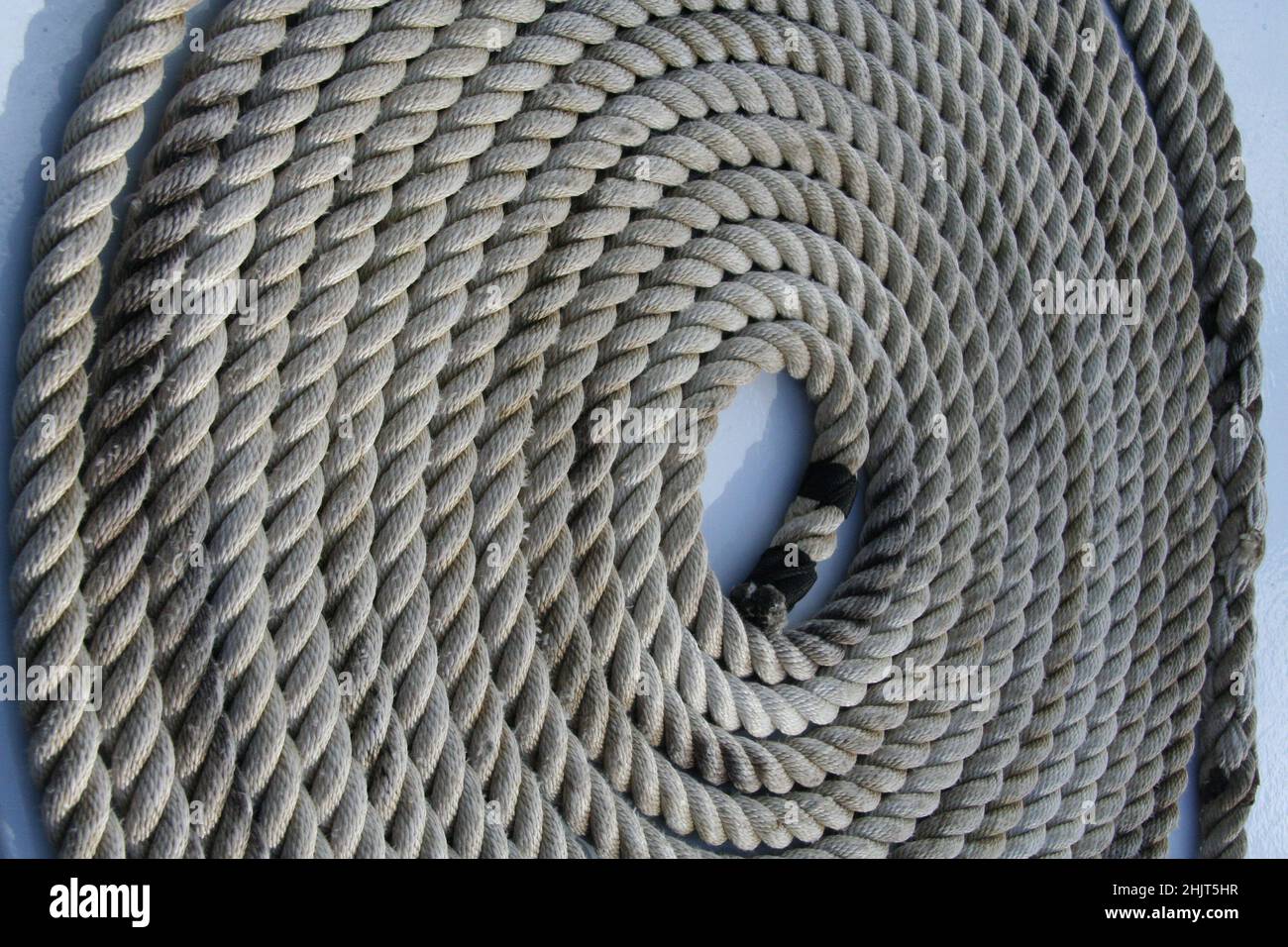 Closeup of a rope coil on a white metallic surface Stock Photo - Alamy