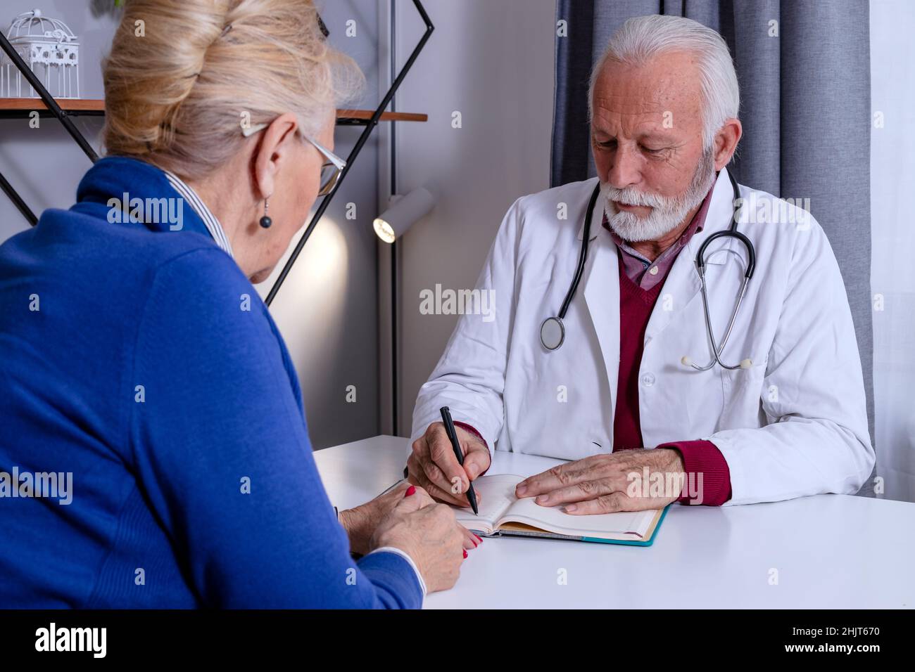 Experienced doctor discussing with senior female patient her private ...