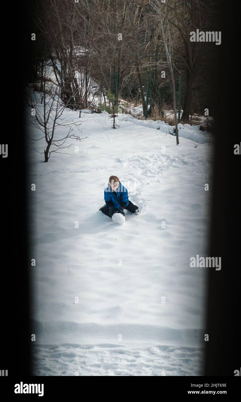 Boy making a snowman Stock Photo - Alamy