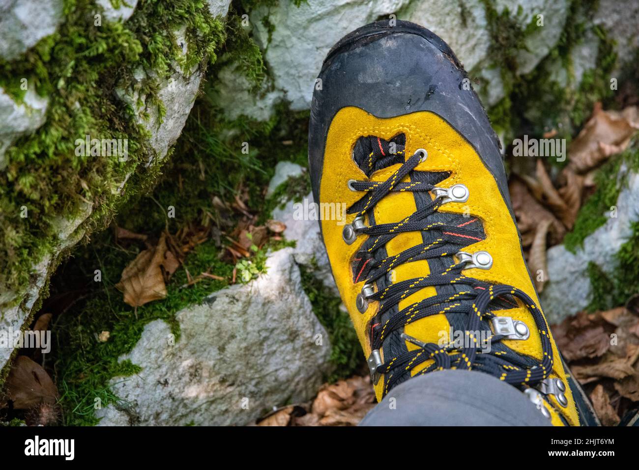 Black yellow hiking boot photographed from above in front of rocky ...