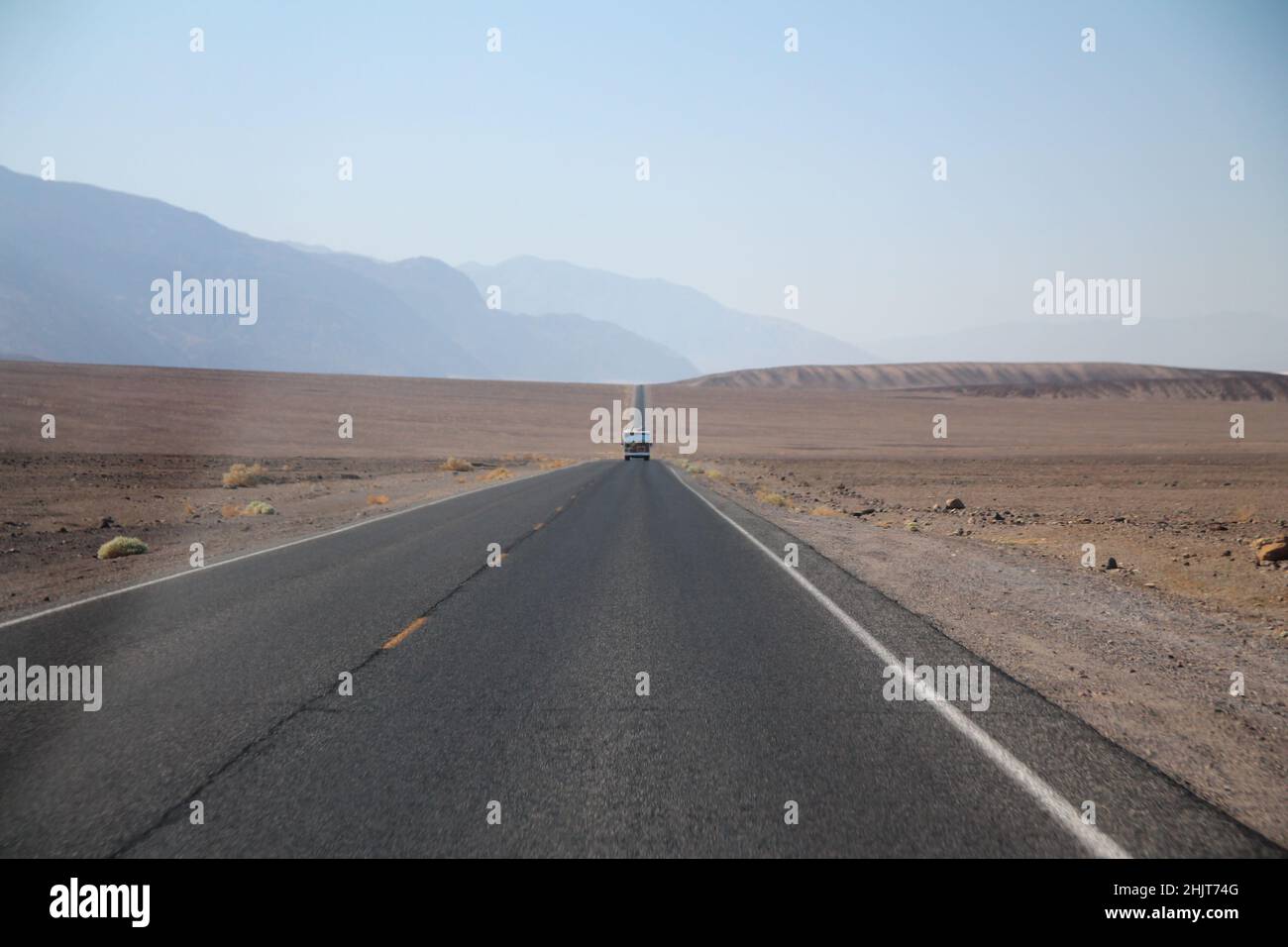 The straight and long street in the middle of the Death Valley desert ...