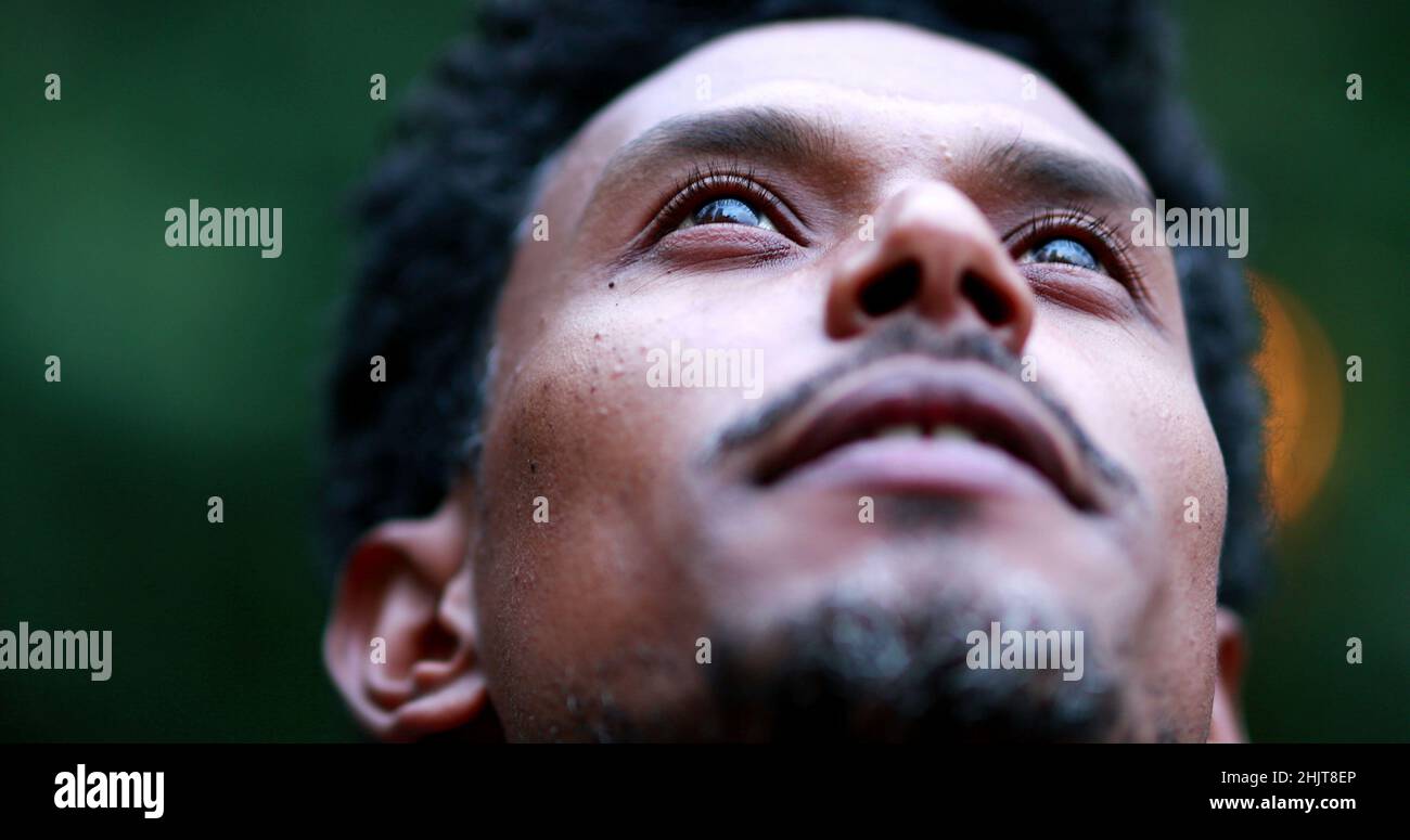 African man face close-up opening eyes to the sky smiling Stock Photo ...