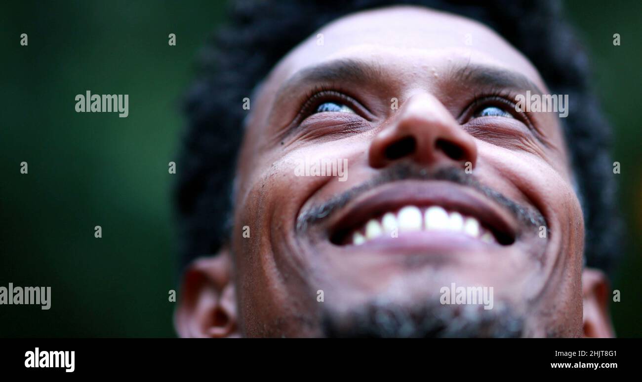 African man face close-up opening eyes to the sky smiling Stock Photo ...