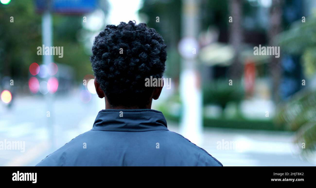 Back of man walking in city street, african american person walks in ...
