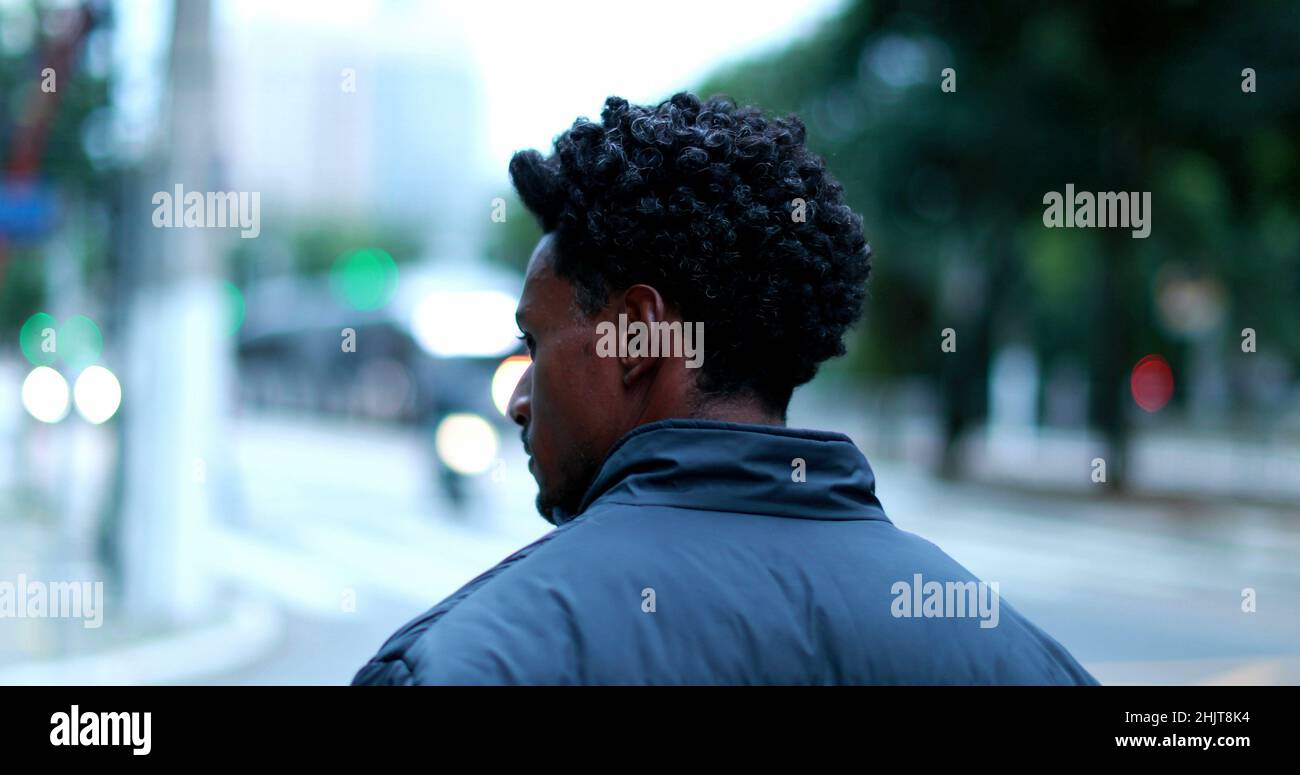 Back of man walking in city street, african american person walks in ...