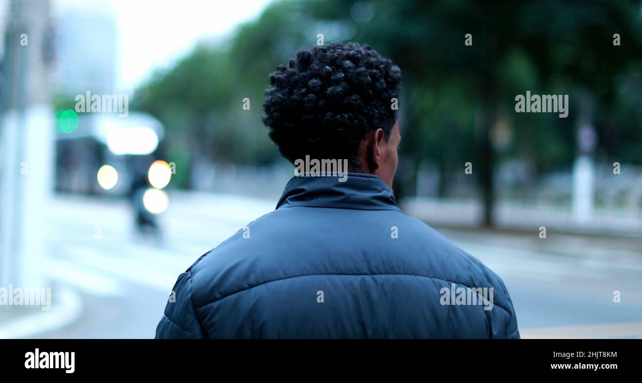 Back of man walking in city street, african american person walks in ...