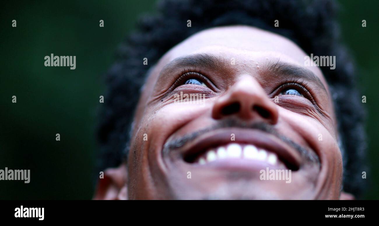 Black man meditating outside taking a deep breath and opening eyes to ...
