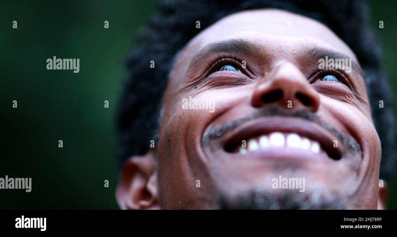 Black man meditating outside taking a deep breath and opening eyes to ...