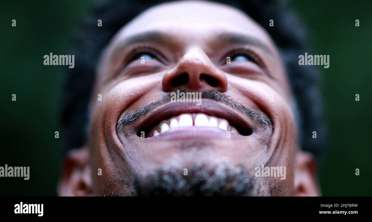 Black man meditating outside taking a deep breath and opening eyes to ...