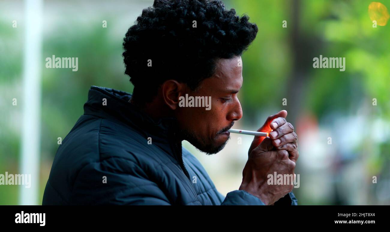 Candid African american smoking cigarette outside Stock Photo - Alamy