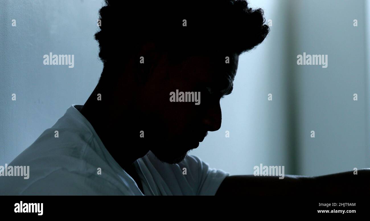 Depressed man sitting on floor. Sad unhappy person holding his forehead ...