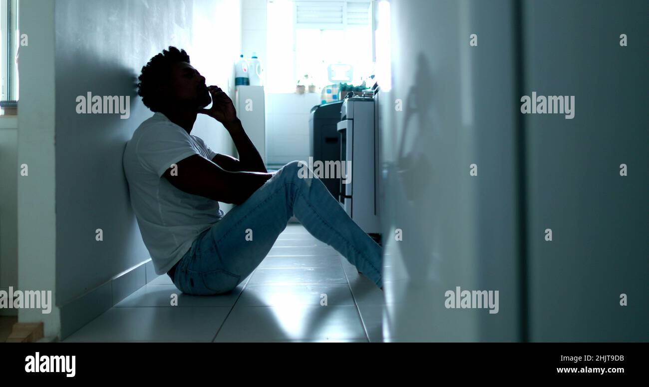 Man feeling emotional pain sitting on kitchen floor feeling desperate ...