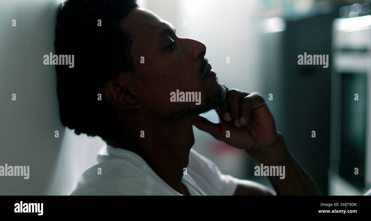 Frustrated black man sitting on home floor feeling concerned, african ...