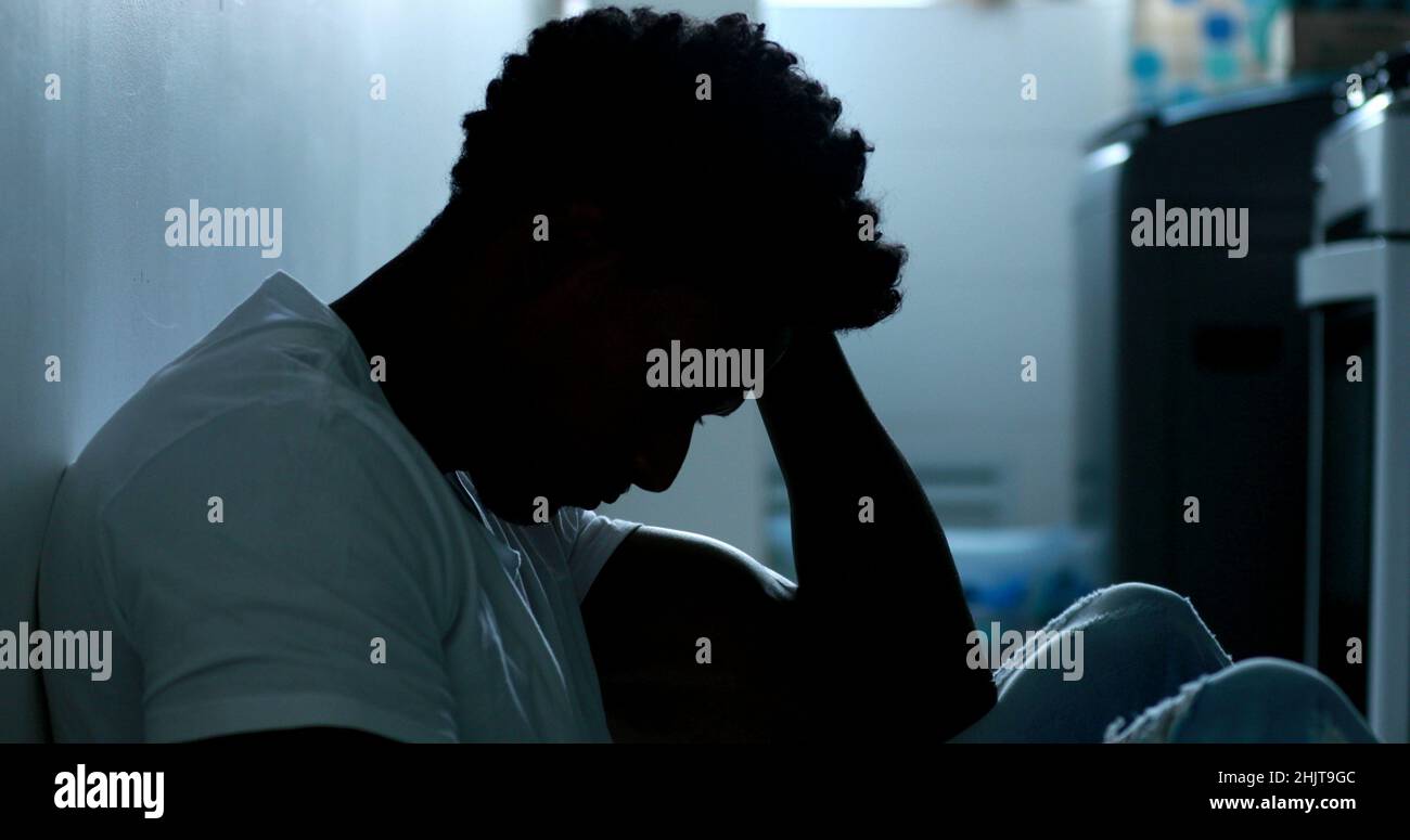 Man feeling emotional pain sitting on kitchen floor feeling desperate ...