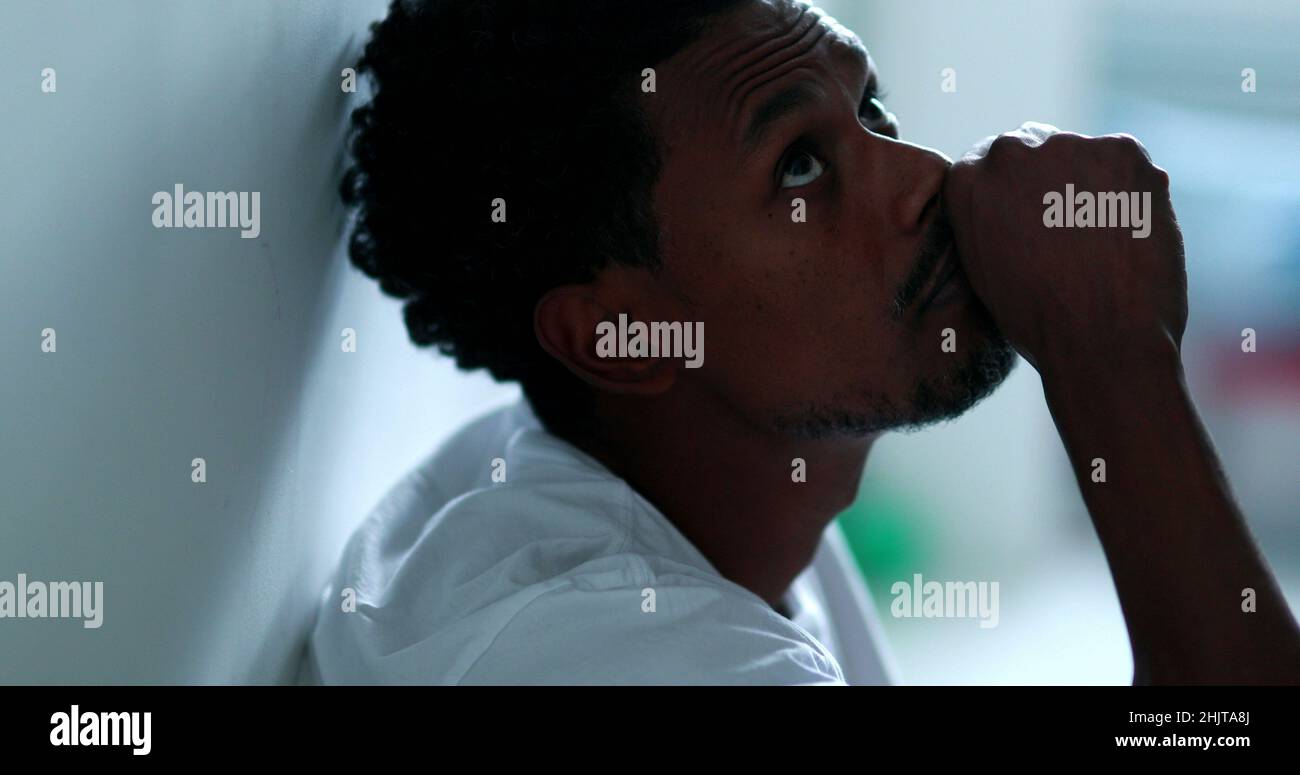 Worried black man feeling distraught and preoccupied sitting on home ...