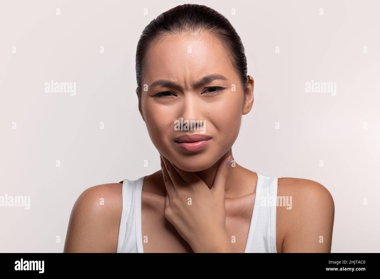 Unhealthy chinese lady touching her neck, closeup Stock Photo - Alamy